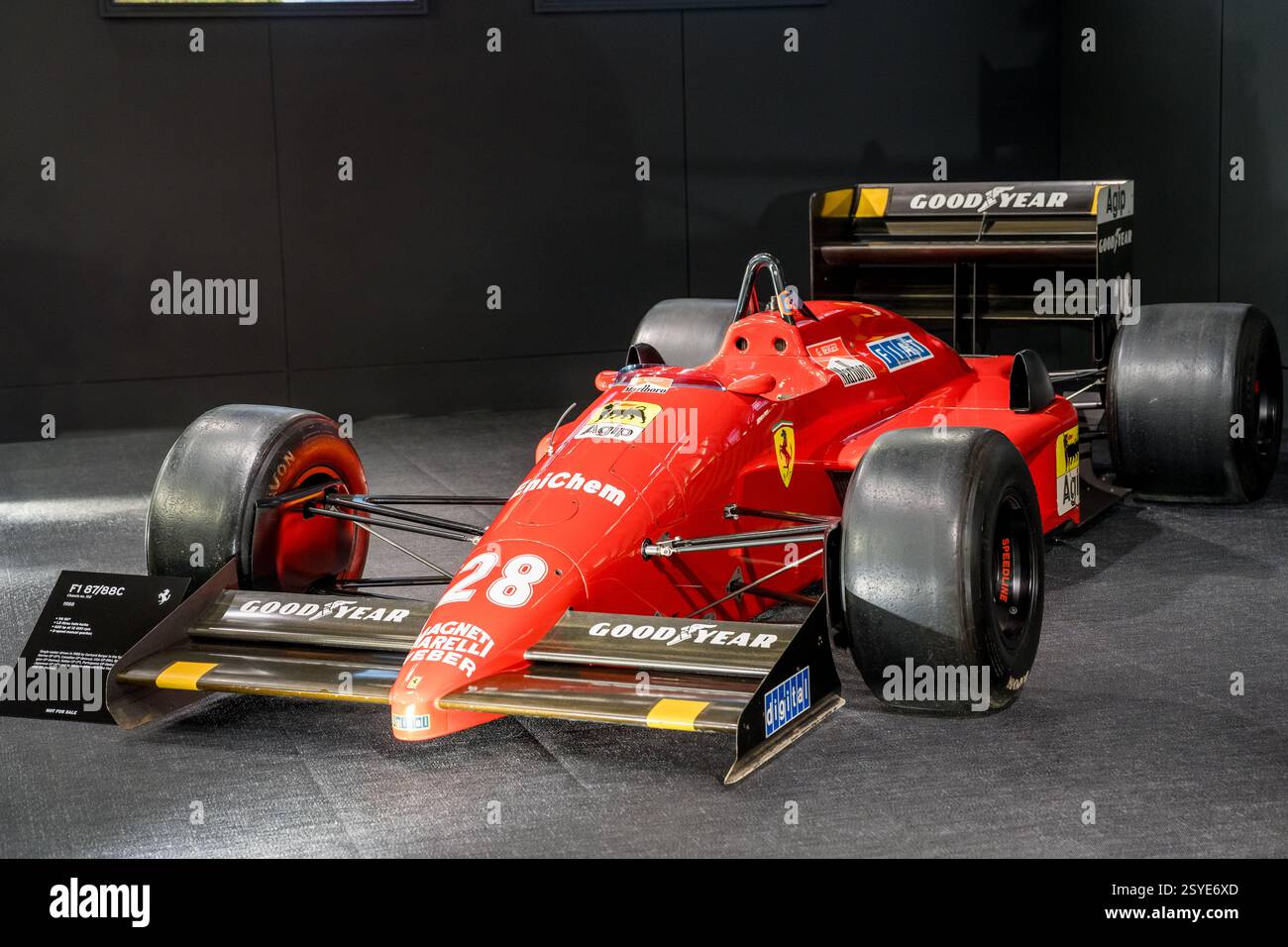 Iconic red racing car displayed in an exhibition hall showcasing the ...