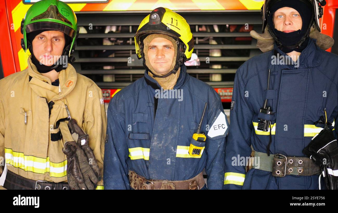 Portrait of male firefighters in helmets and protective uniforms ...