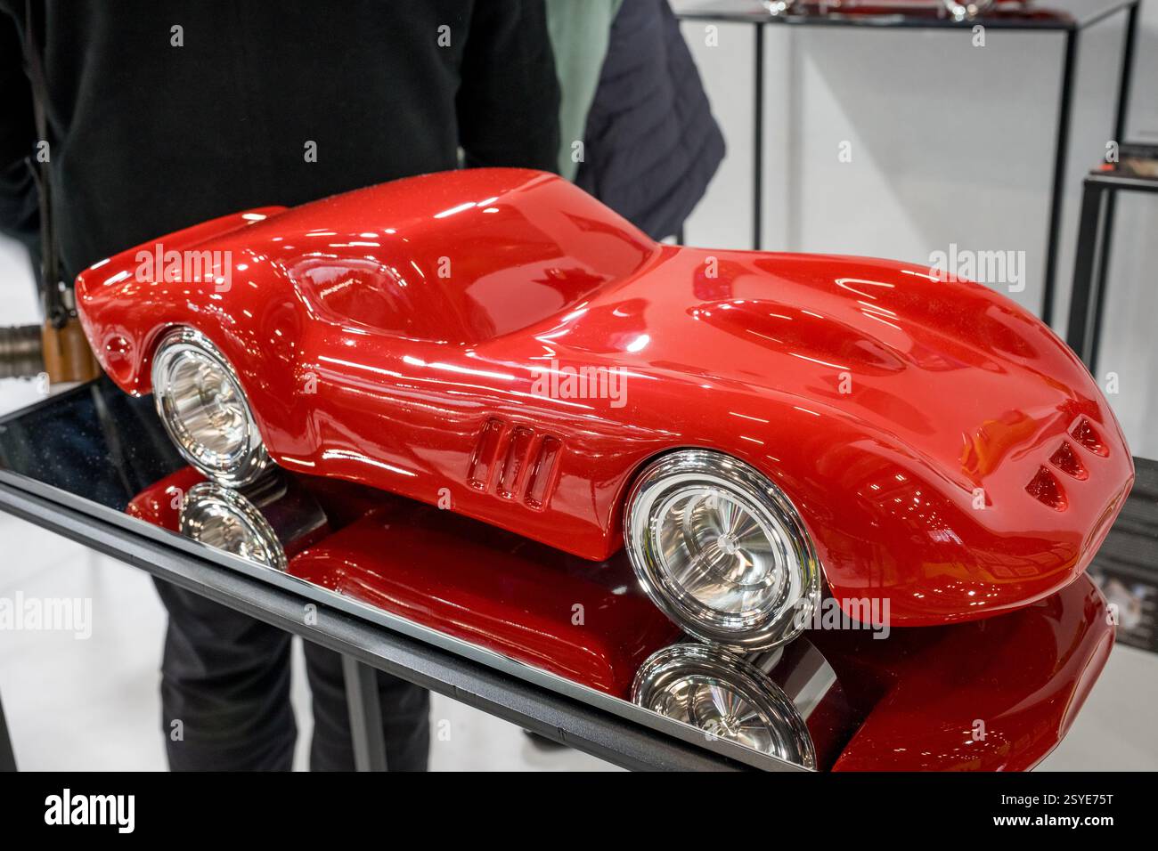 Elegant red sports car model displayed at an automotive exhibition ...