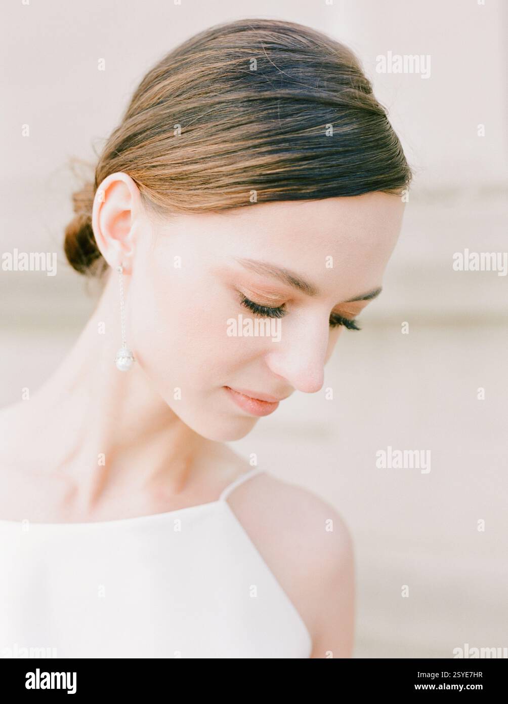 Bride with gentle features and elegant hairstyle in outdoor setting ...