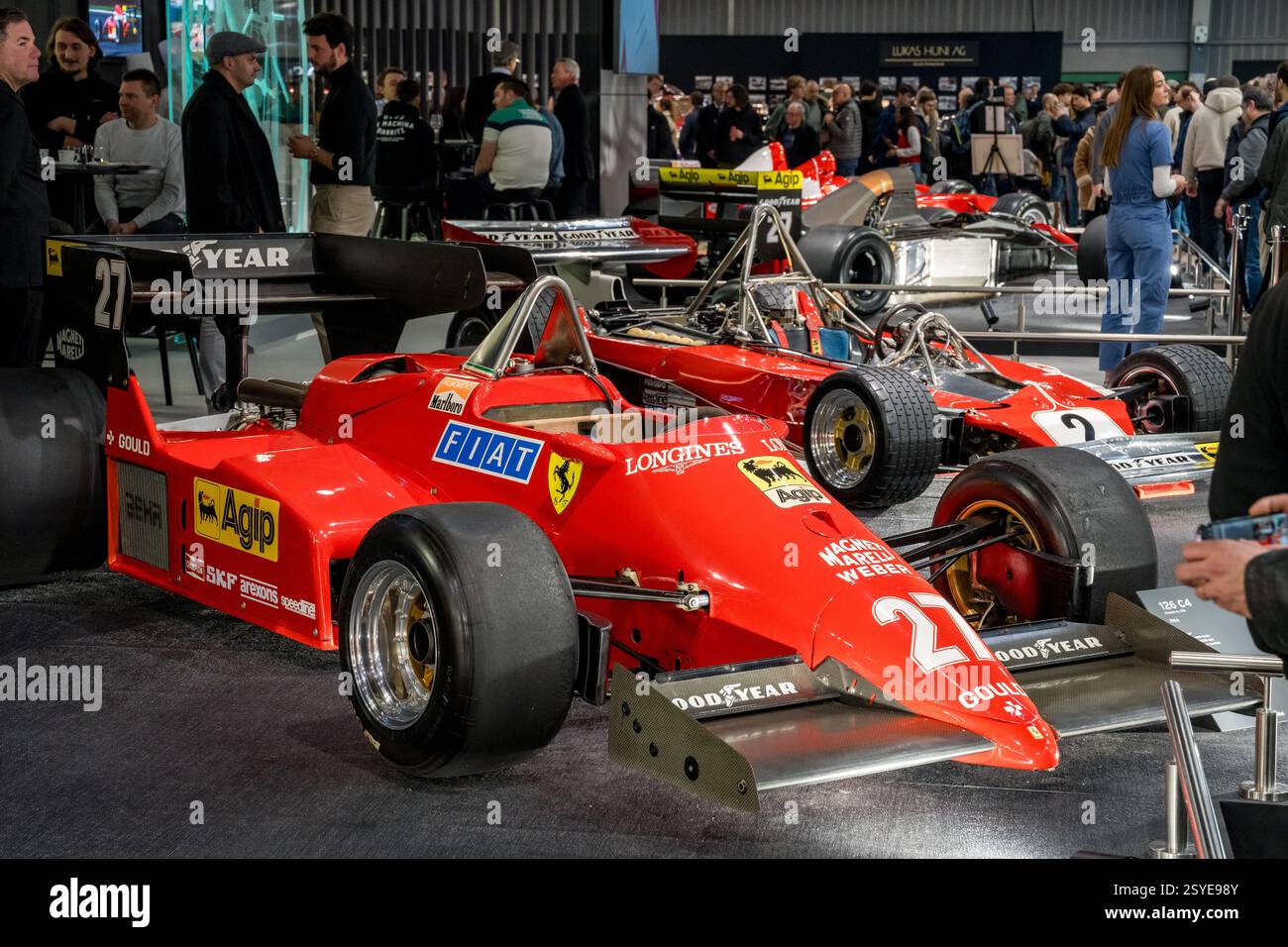 Classic racing cars on display at a vibrant indoor exhibition, enticing ...