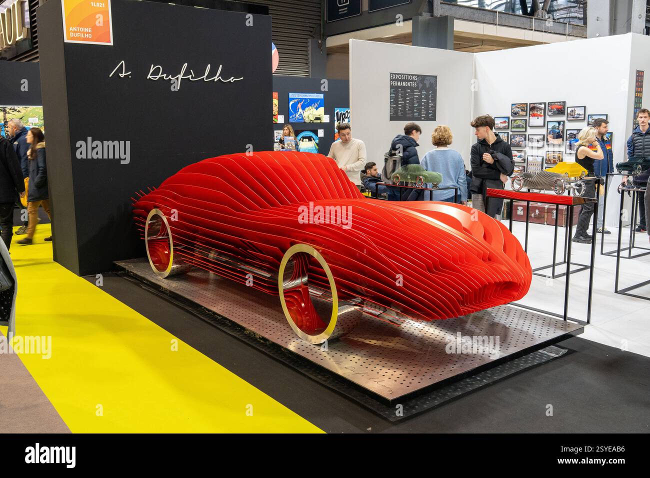 Striking red automotive sculpture on display at an art exhibit ...