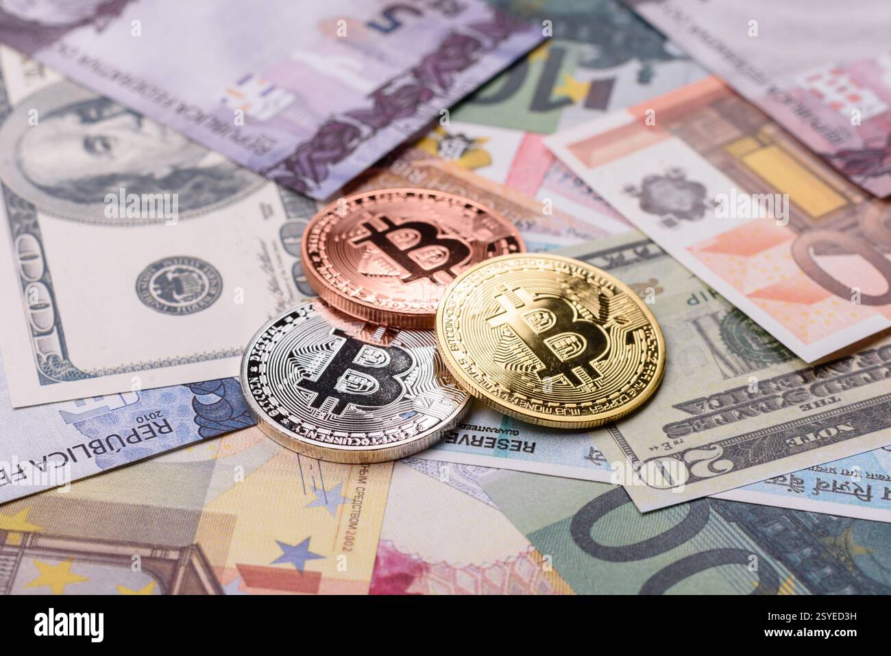 Round metal bitcoin on a background of paper banknotes of different ...
