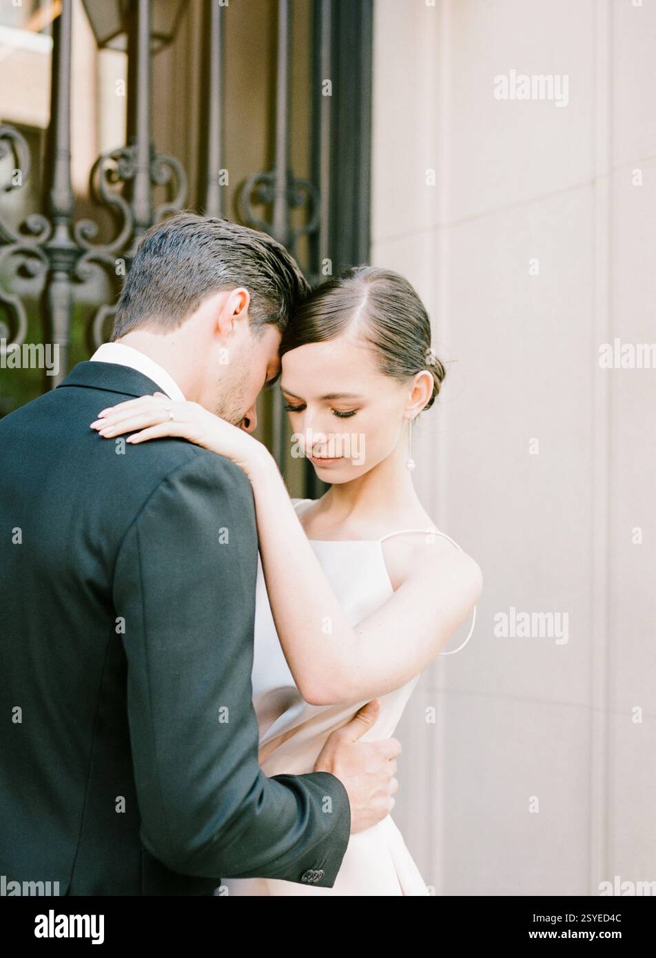 A romantic couple leans into each other, sharing a tender moment while ...