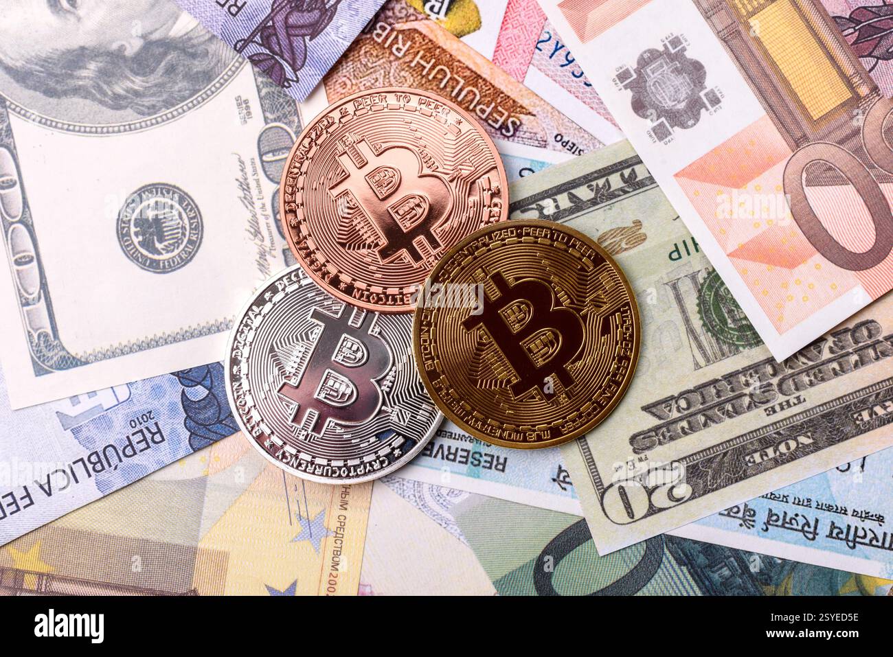 Round metal bitcoin on a background of paper banknotes of different ...