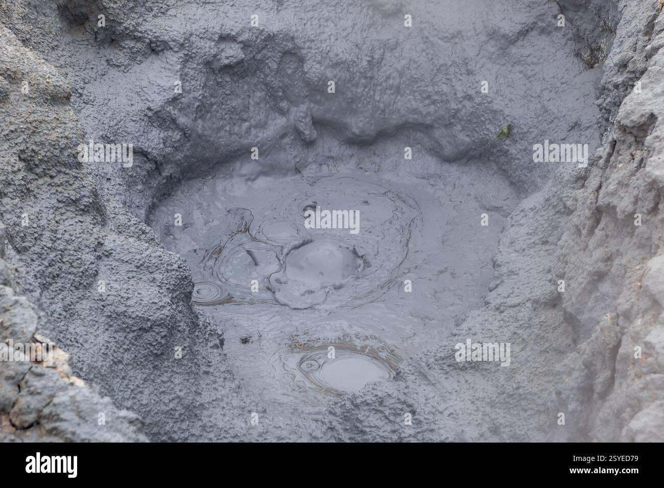 Mud bubbling in a hole at the geothermal active area of Hverir in ...