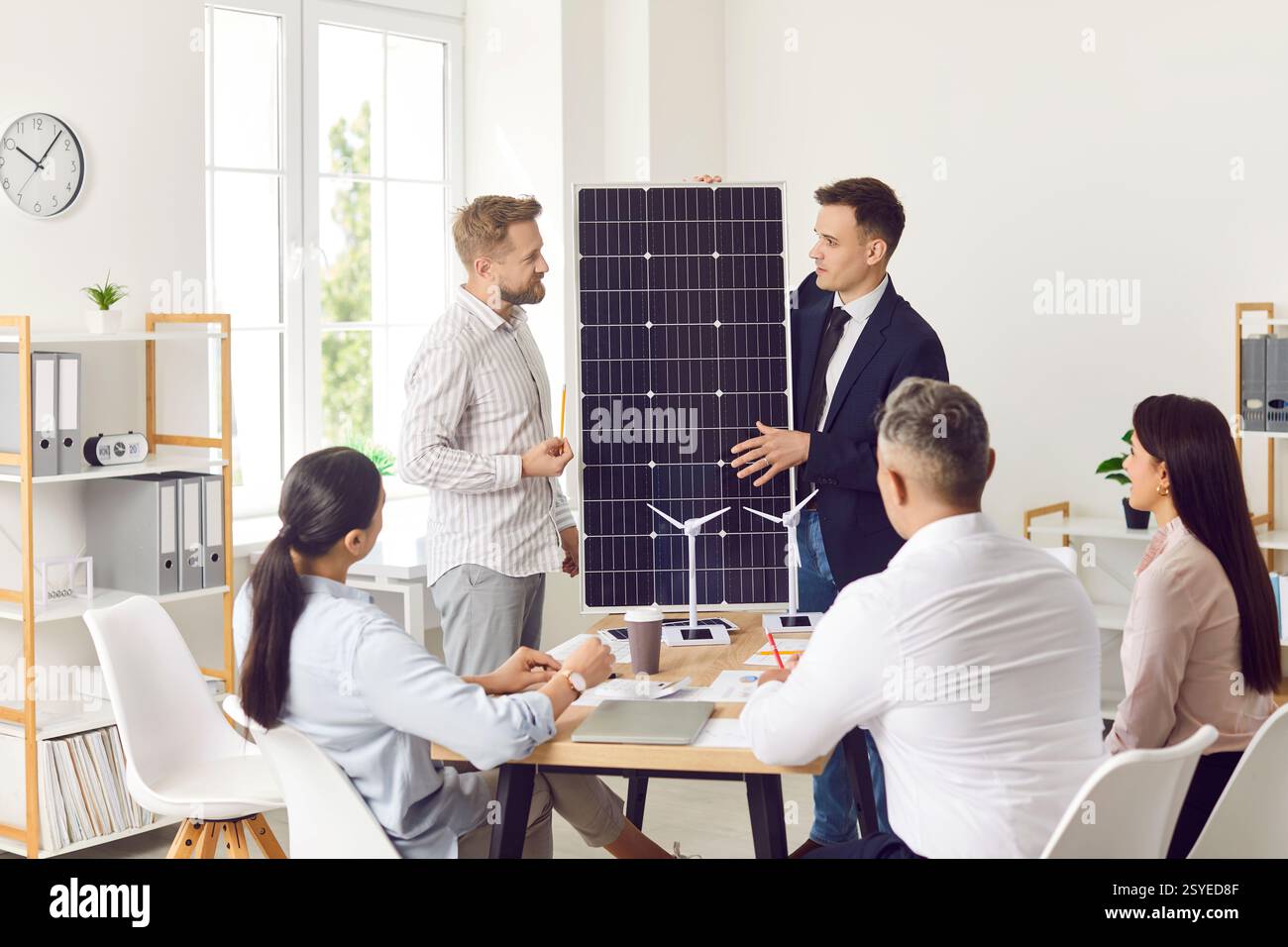 Employees holding solar panel device speaking presenting new component ...