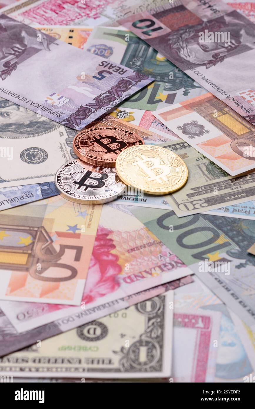 Round metal bitcoin on a background of paper banknotes of different ...