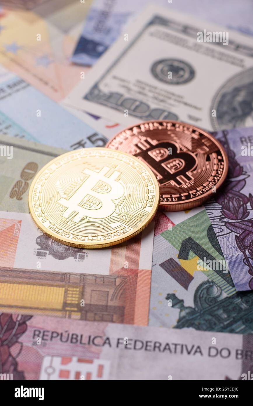 Round metal bitcoin on a background of paper banknotes of different ...