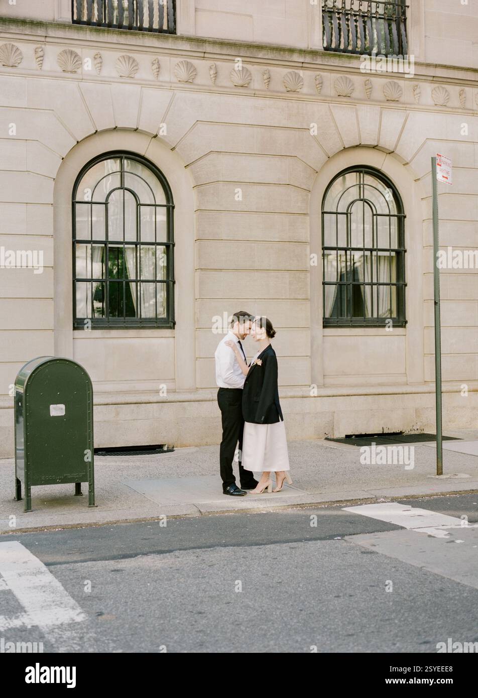 A couple embraces and shares a tender moment on a street surrounded by ...