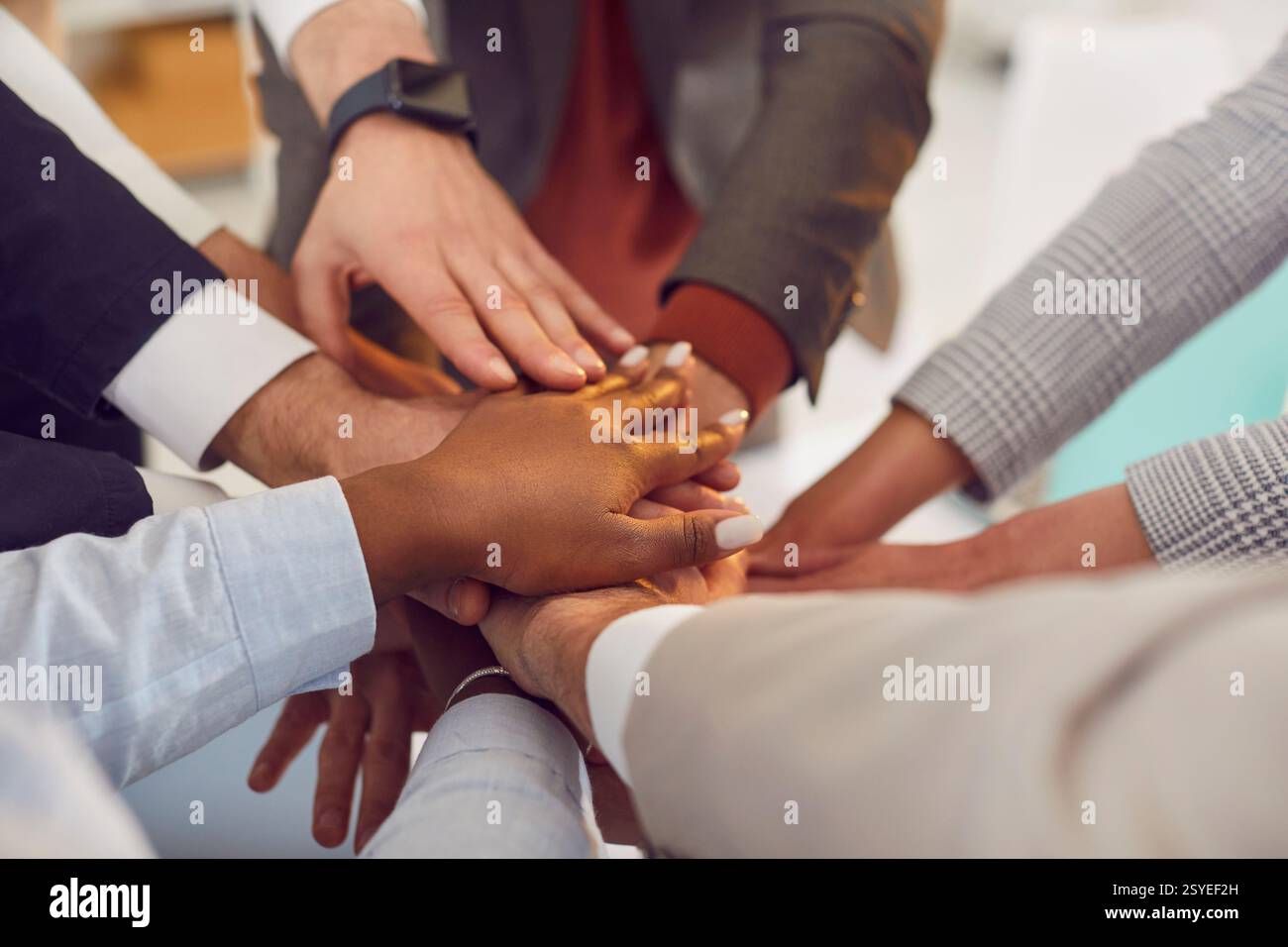 Close up top view photo of diverse business people putting their arms together in stack Stock ...