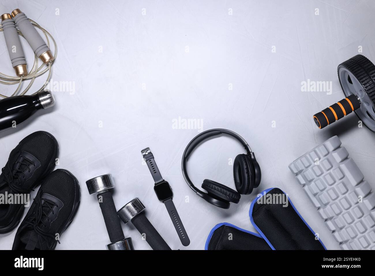 Different gym stuff, wrist watch and headphones on light grey textured ...