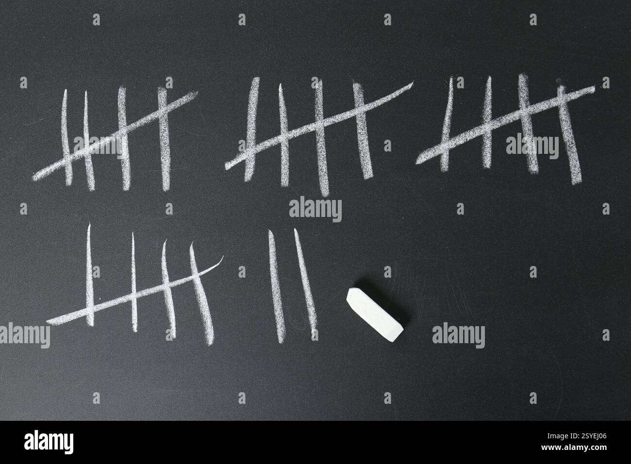 Counting days by drawing sticks with chalk on blackboard, top view ...