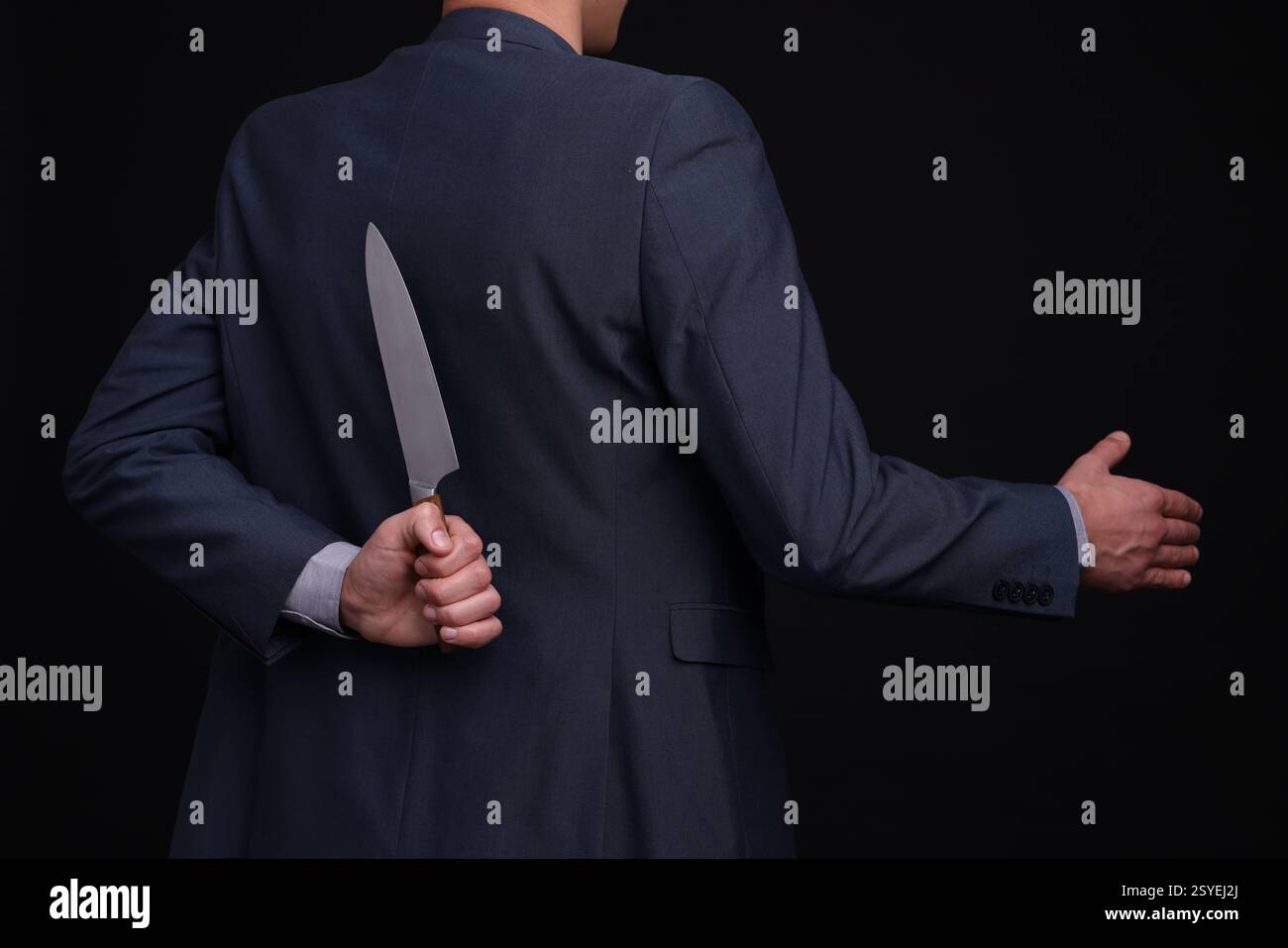 Businessman holding knife behind his back and offering handshake on ...