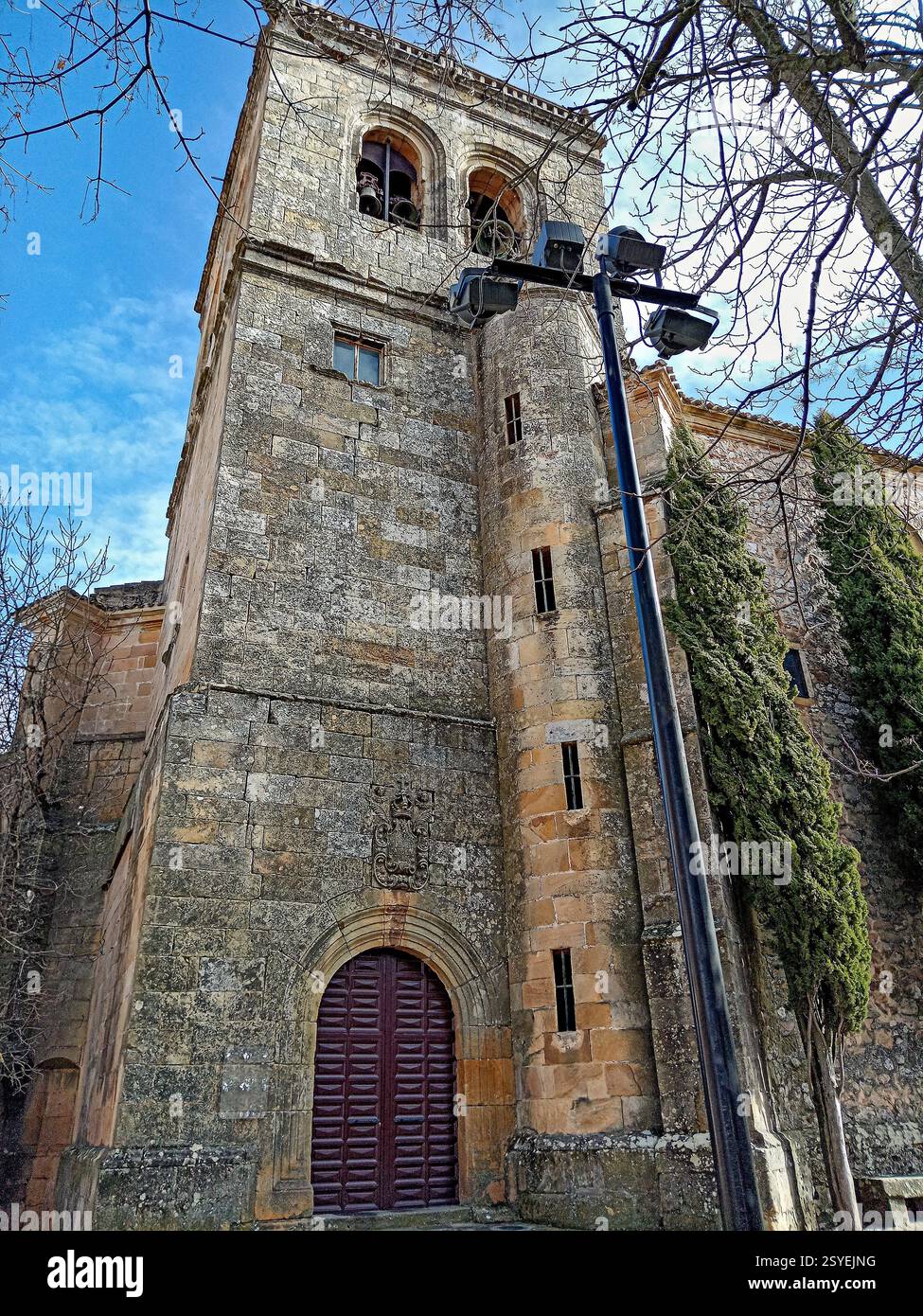 Old stone church in Soria, Spain, featuring a tall bell tower, arched ...