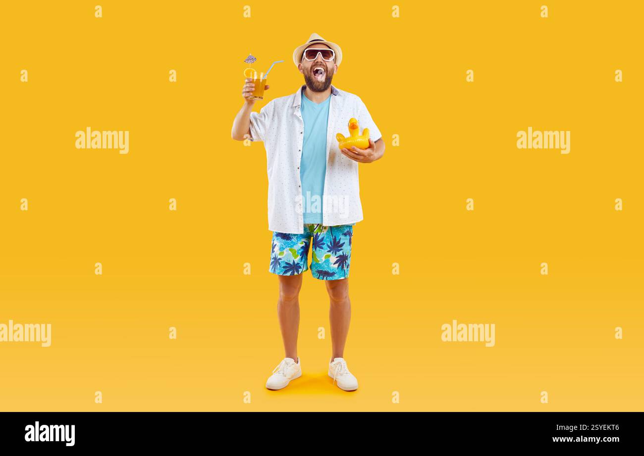 Happy funny male tourist with toy duck enjoys cocktails on summer ...