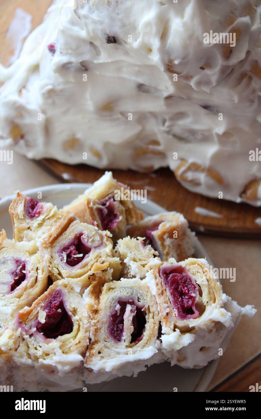 A plate with a cherry cake covered with butter cream on top, pyramid ...