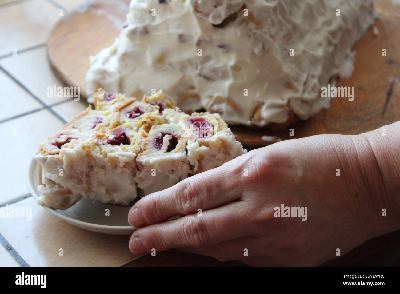 A plate with a cherry cake covered with butter cream on top, pyramid ...