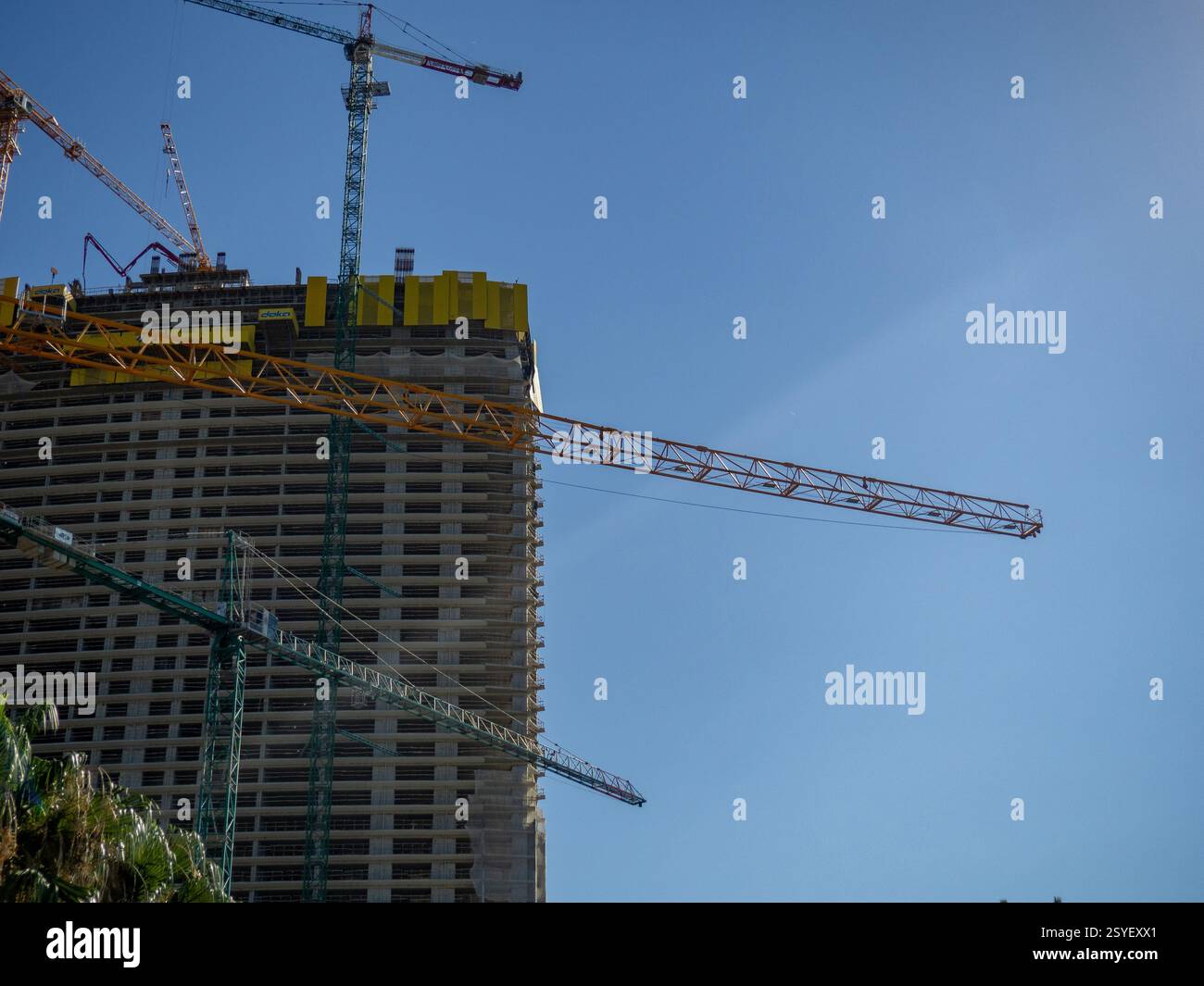 Many cranes over the building under construction. Modern construction. Cement and concrete ...