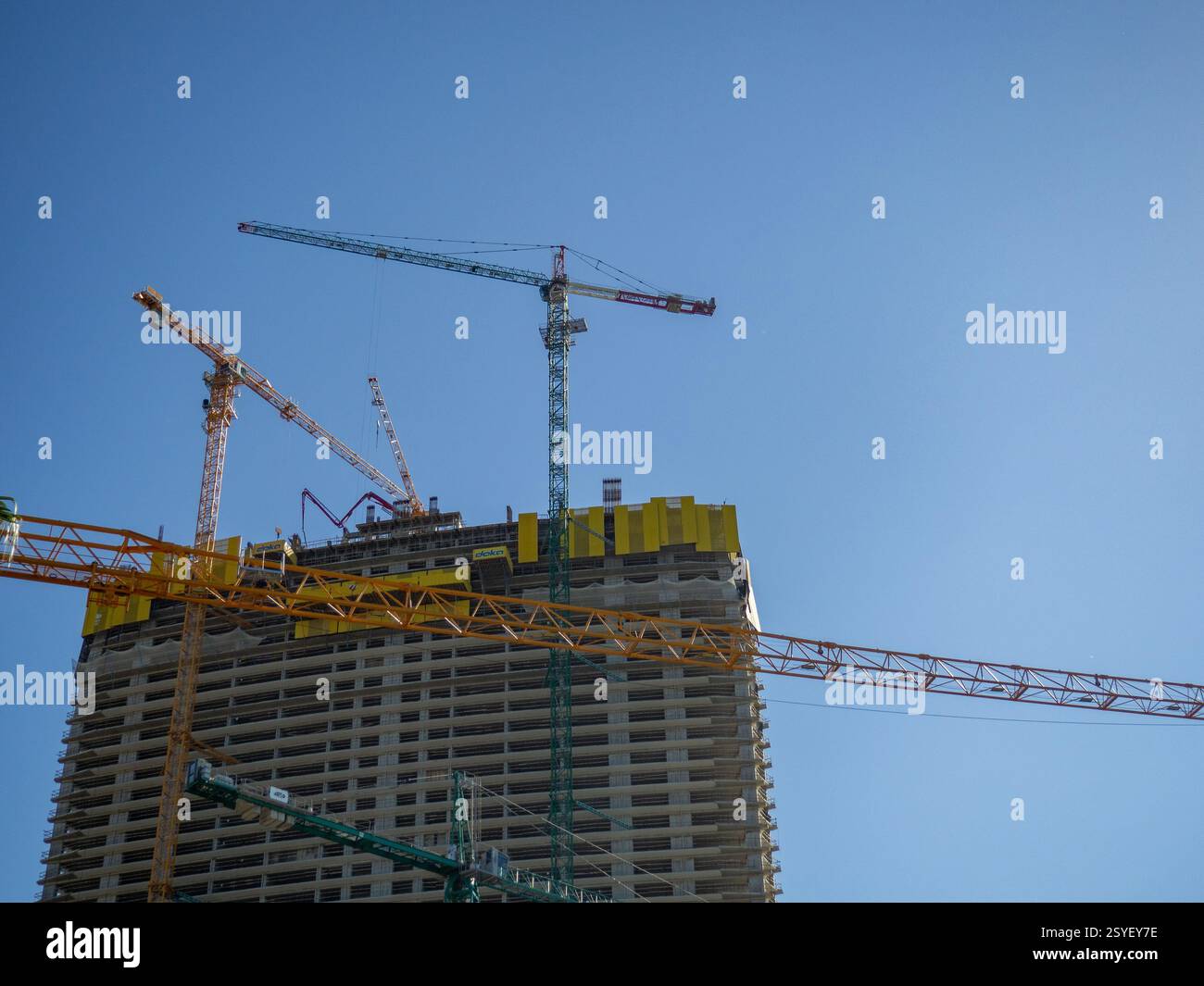 Many cranes over the building under construction. Modern construction. Cement and concrete ...