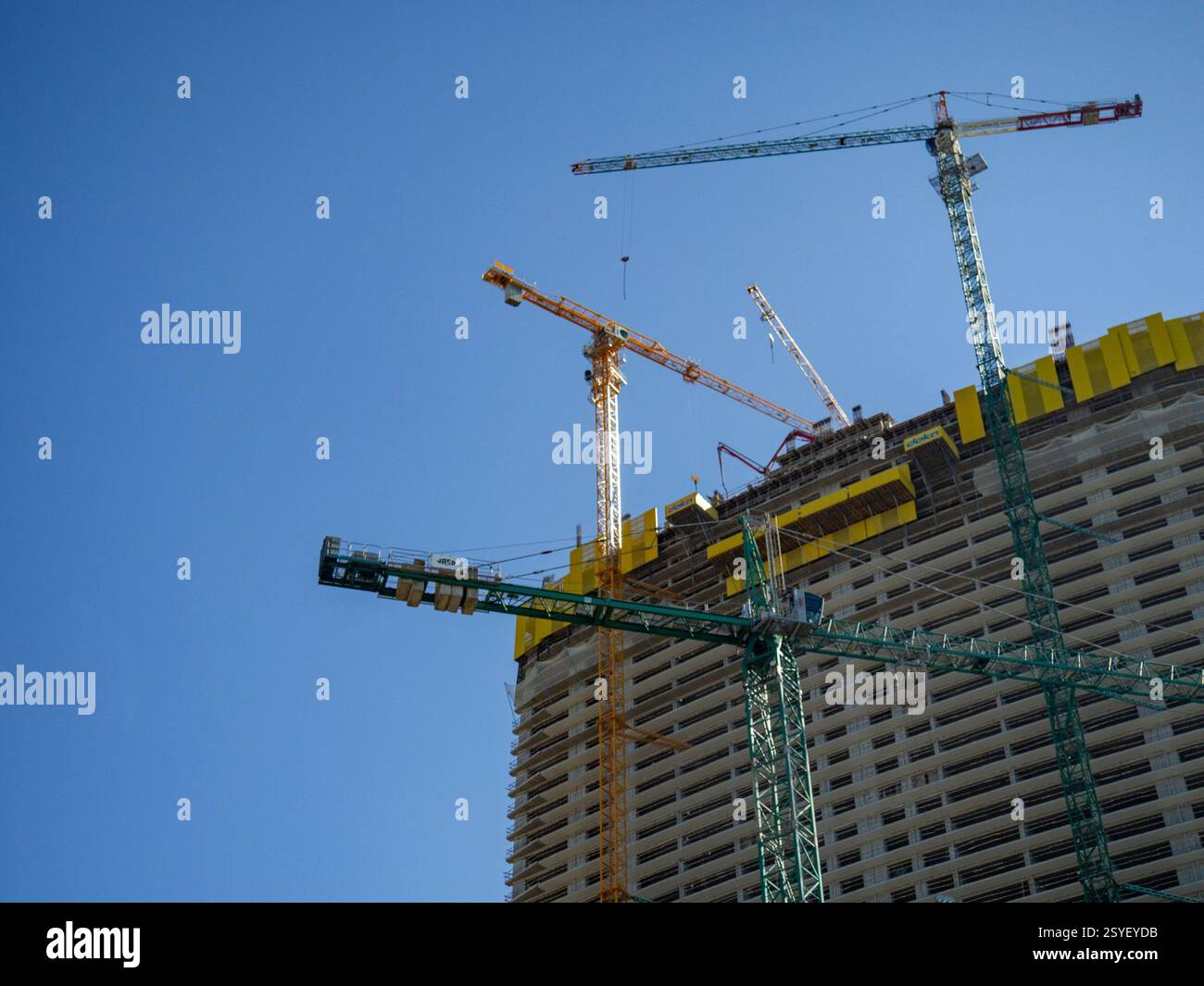 Many cranes over the building under construction. Modern construction. Cement and concrete ...