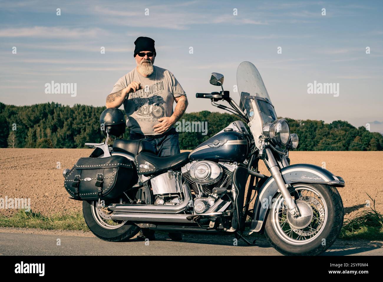 Tätowierter Biker mit Harley Davidson T-Shirt posiert auf seiner ...
