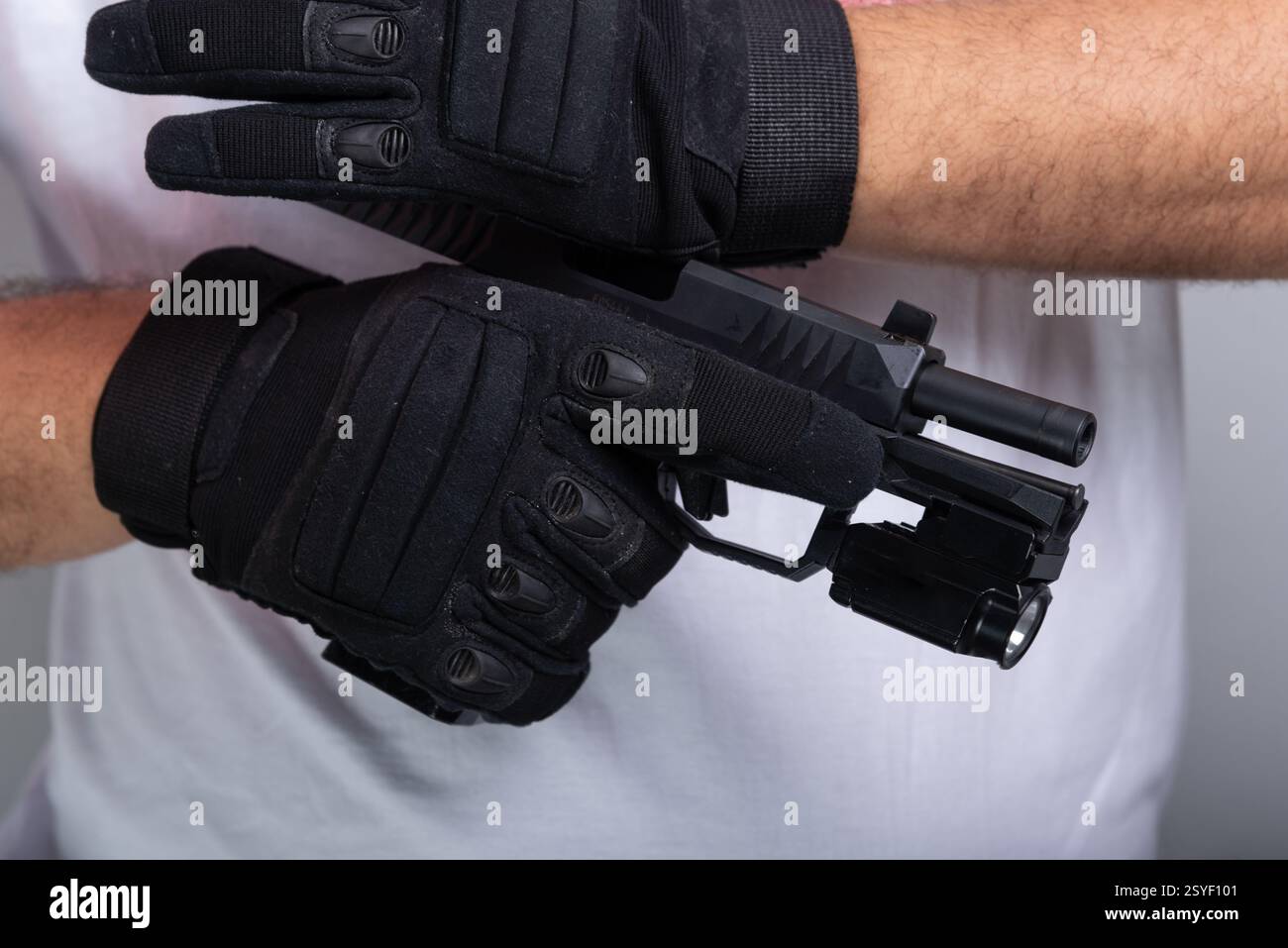 Detail of shooting instructor wearing black gloves cocking a gun ...