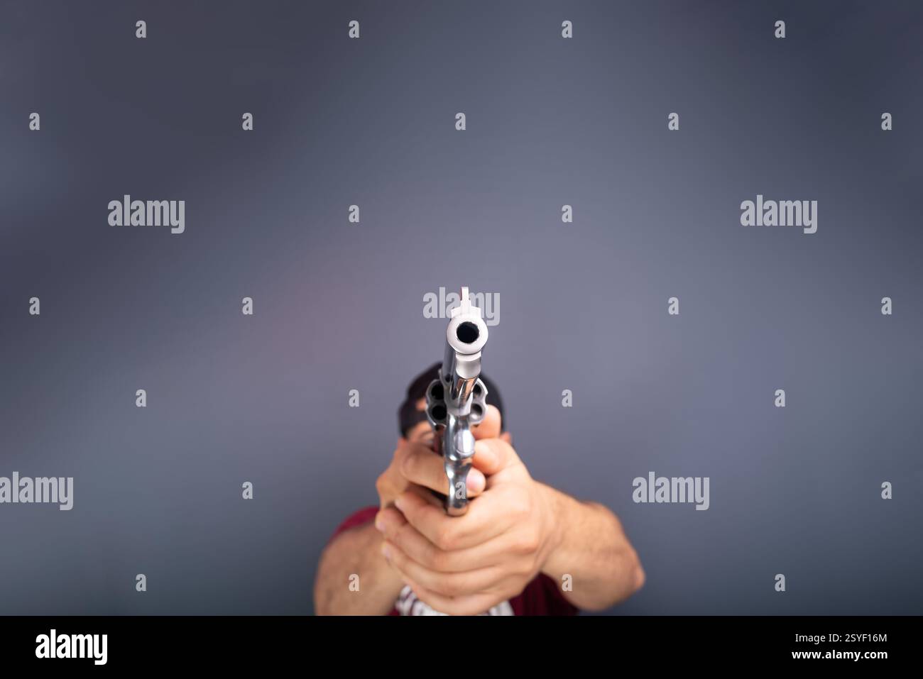 Studio portrait of a shooting instructor pointing a revolver to the ...