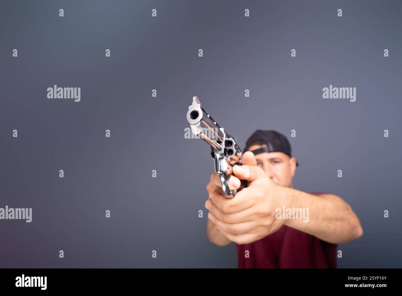 Studio portrait of a shooting instructor pointing a revolver to the ...