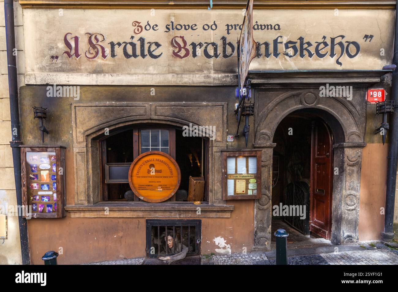 A vintage tavern facade with a painted sign, arched doorway, and small ...
