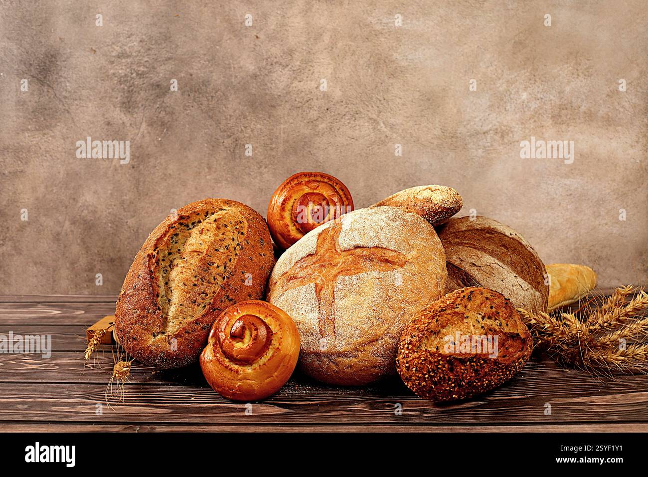 Freshly baked bakery products on wooden background. Whole grain ...