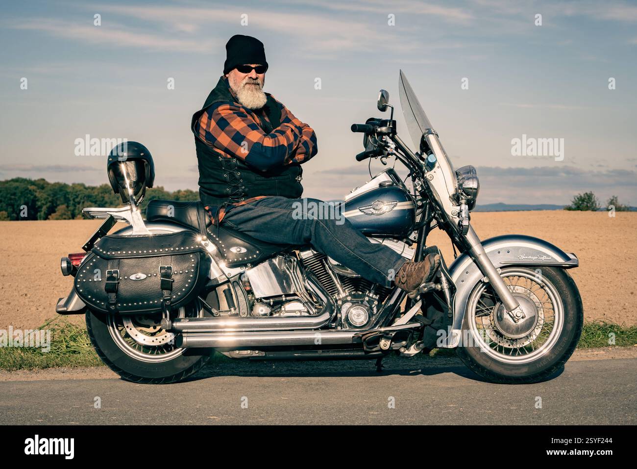 Stolzer Biker mit seiner kultigen Harley-Davidson possiert auf einer ...