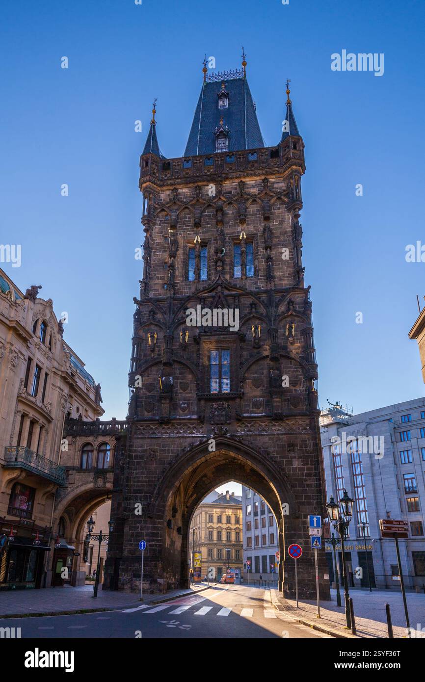 A tall, gothic tower with a dark spire and arched gateway stands ...