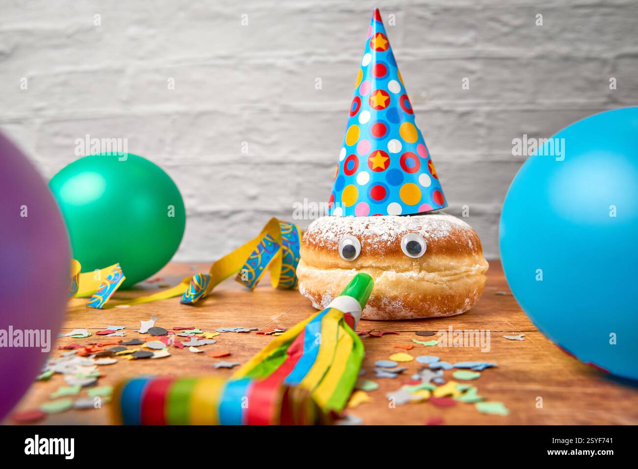 Germany - February 28, 2025: A Berliner with wiggly eyes, a party hat ...