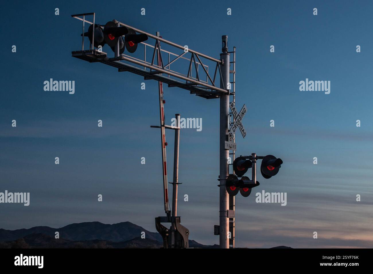 Railroad track crossing arm and warning lights alert motorists to a ...