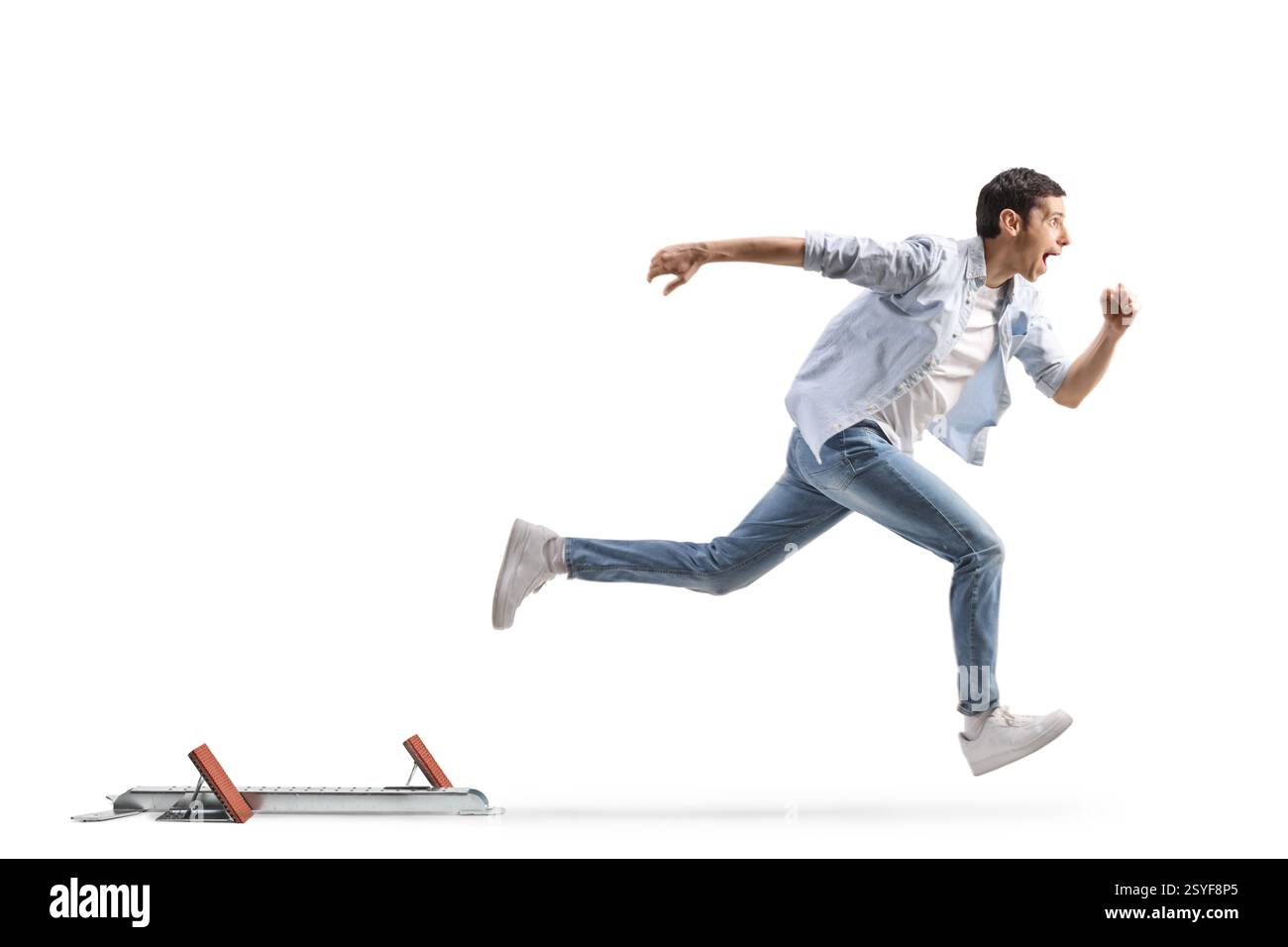 Full length profile shot of a young man in jeans running from start ...