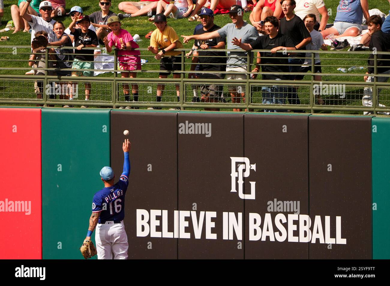 Texas Rangers center fielder Kevin Pillar tosses a ball to children ...