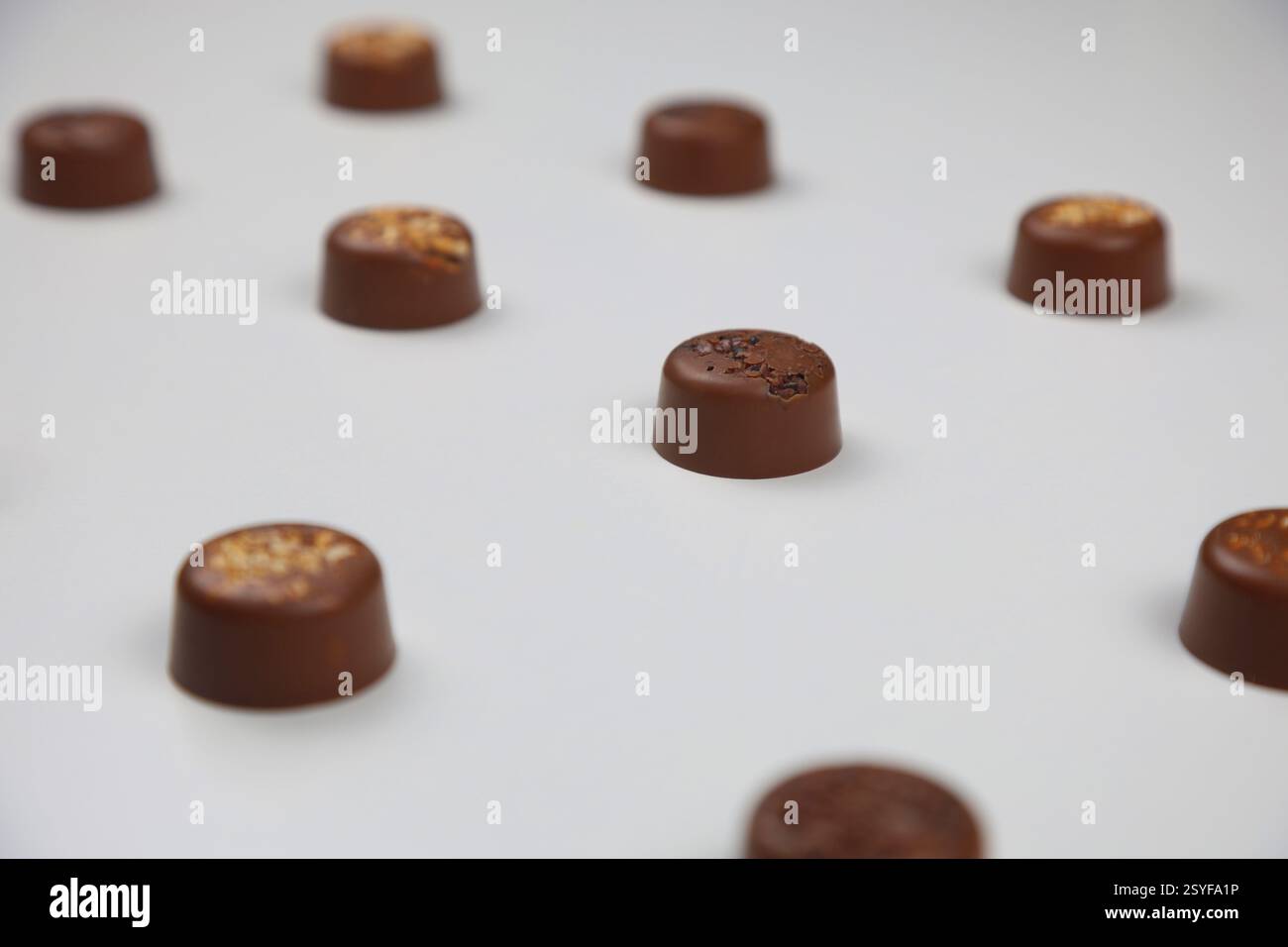 Des chocolats assortis placés côte à côte sur fond blanc, avec un joli ...