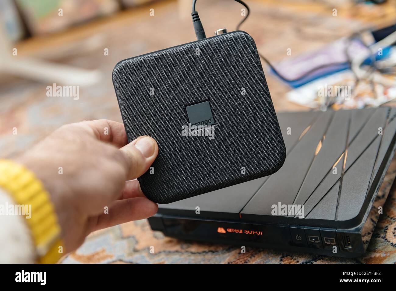 Paris, France - Feb 17, 2025: A person holds the compact Orange TV ...