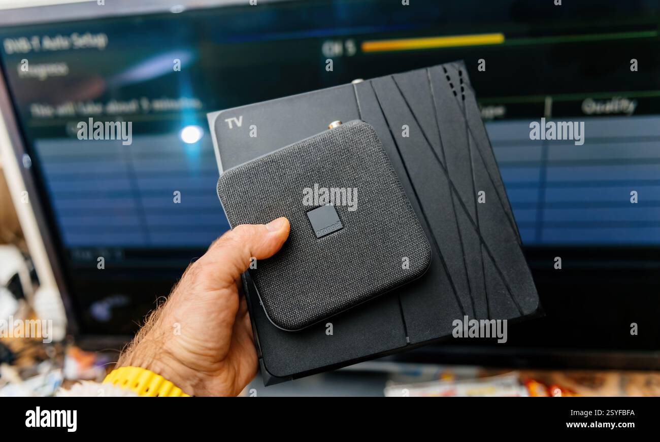 Paris, France - Feb 17, 2025: A person holds a compact Orange TV ...