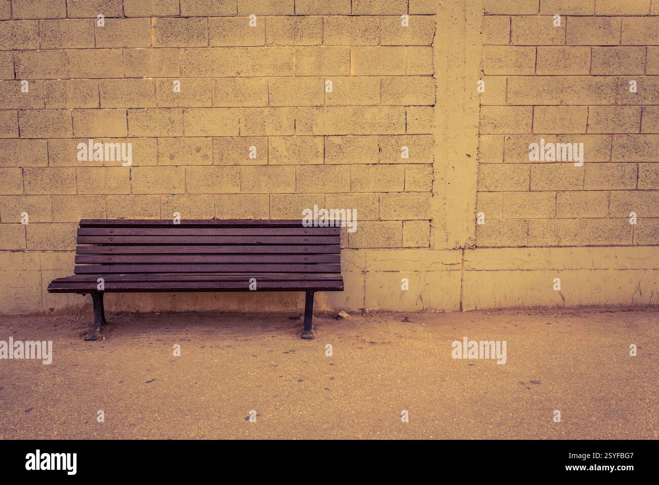 Lonely bench with bricks wall in the back Stock Photo - Alamy