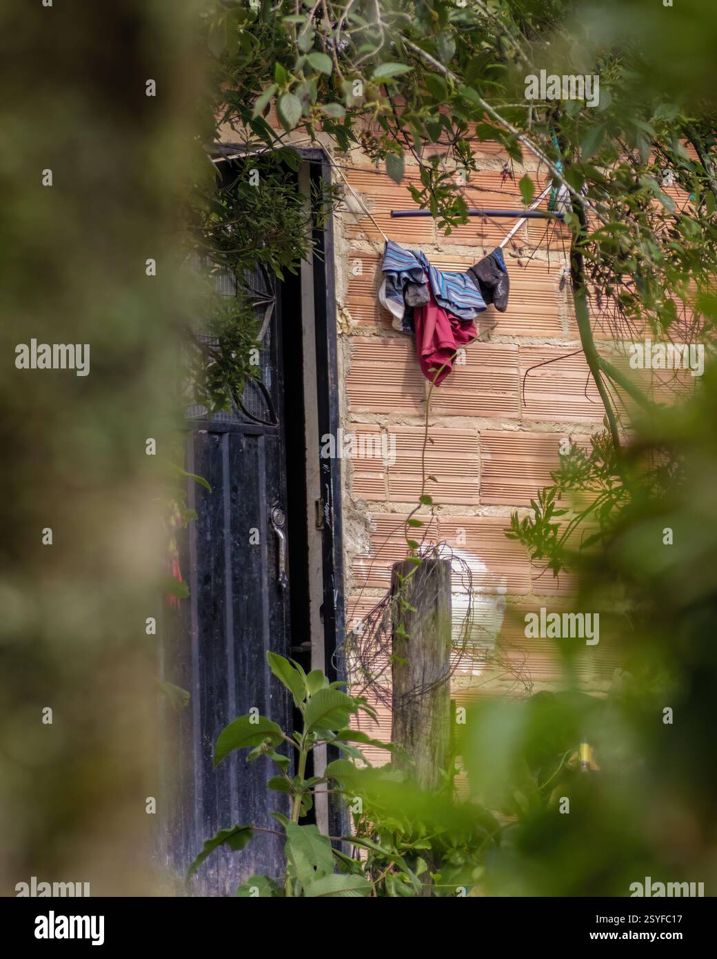 Sneaky view of some clothes hanging against a brick wall outside of a ...