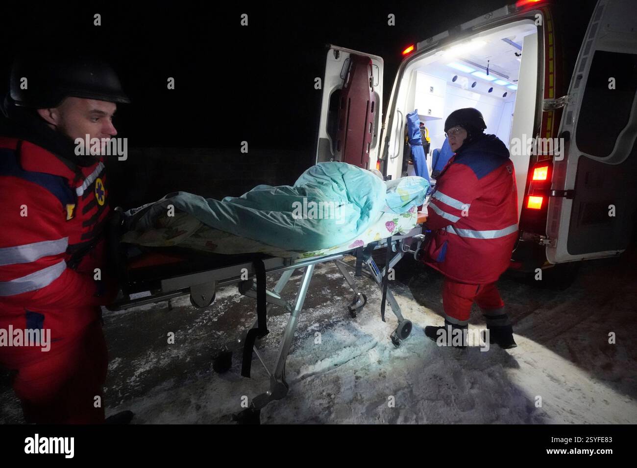 Medical workers evacuate a patient from a hospital damaged by a Russian ...