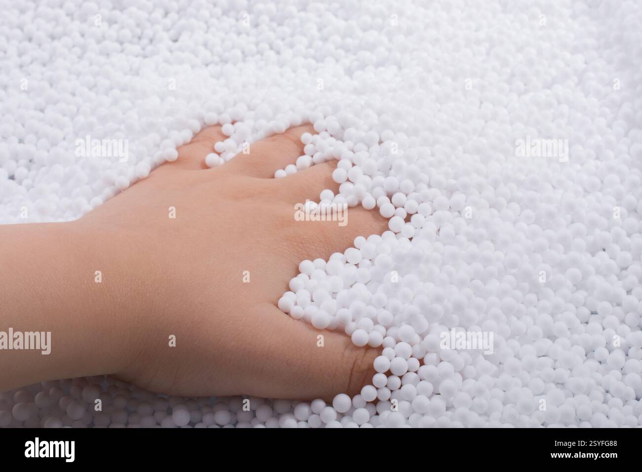 Toddler hand in White polystyrene foam balls as background Stock Photo ...