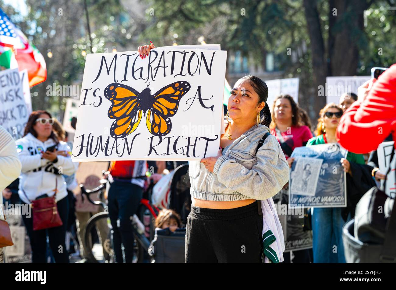 A woman holds up a sign about migration being a human right at the Pro ...
