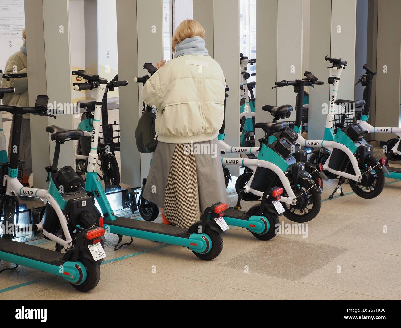 TOKYO, JAPAN - February 18, 2025: Person by a row of Luup rental e ...