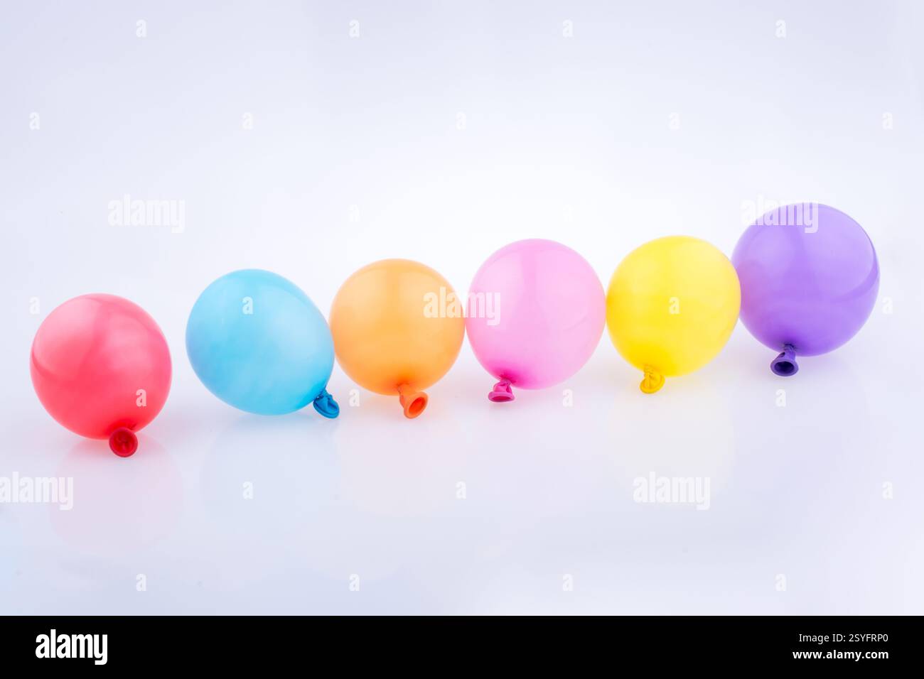 Colorful small balloons in line on a white background Stock Photo - Alamy