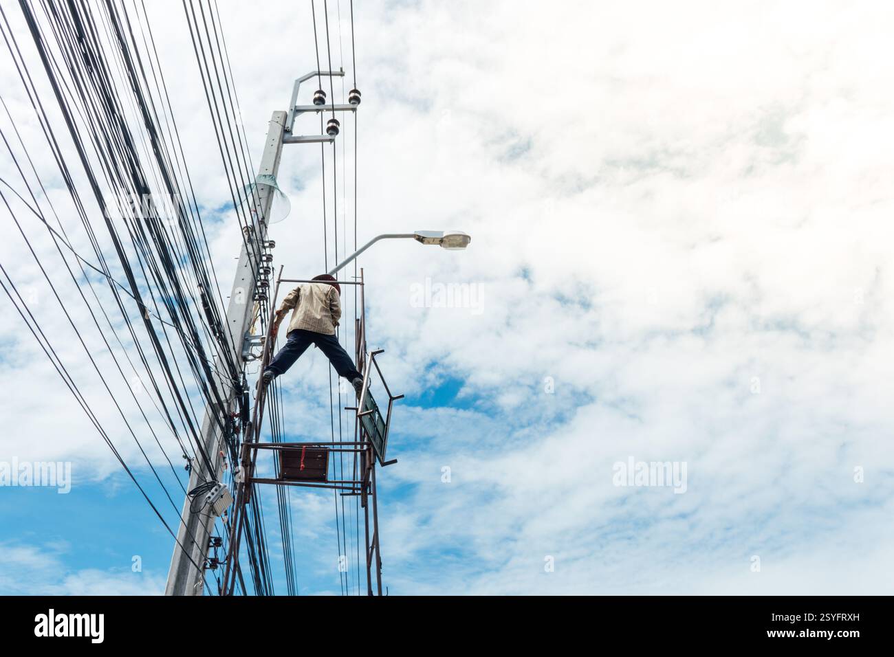 Worker working to install electric line by scaffolding on pickup truck ...