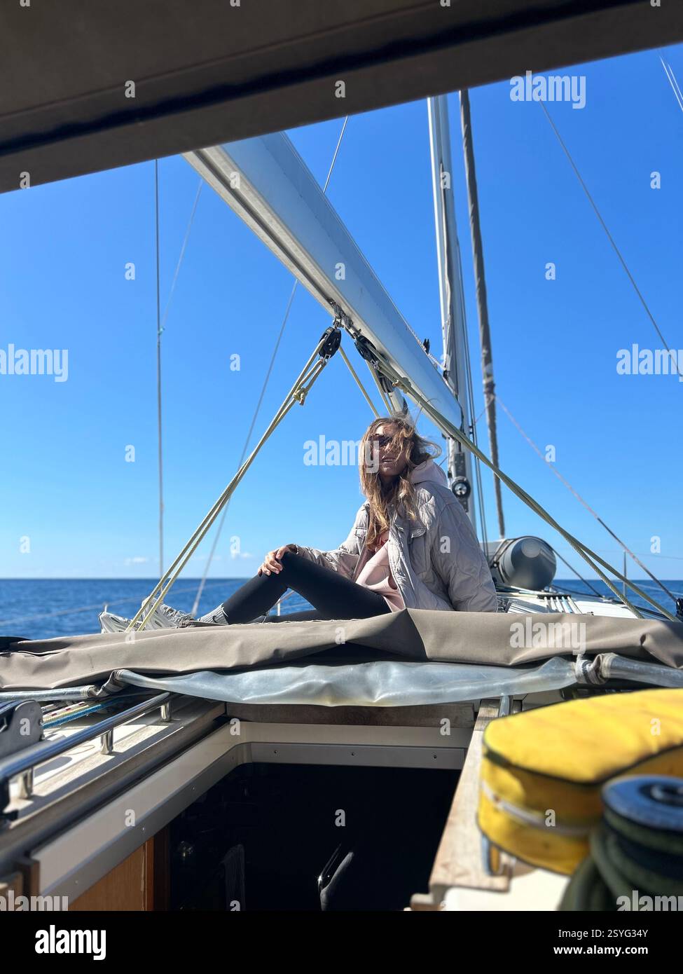 A person relaxes on the deck of a yacht, soaking up the sun and ...