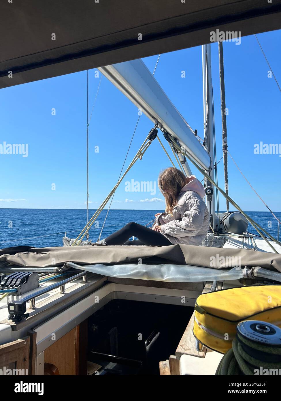 Sailing adventure on a clear day with a young woman relaxing on a boat ...